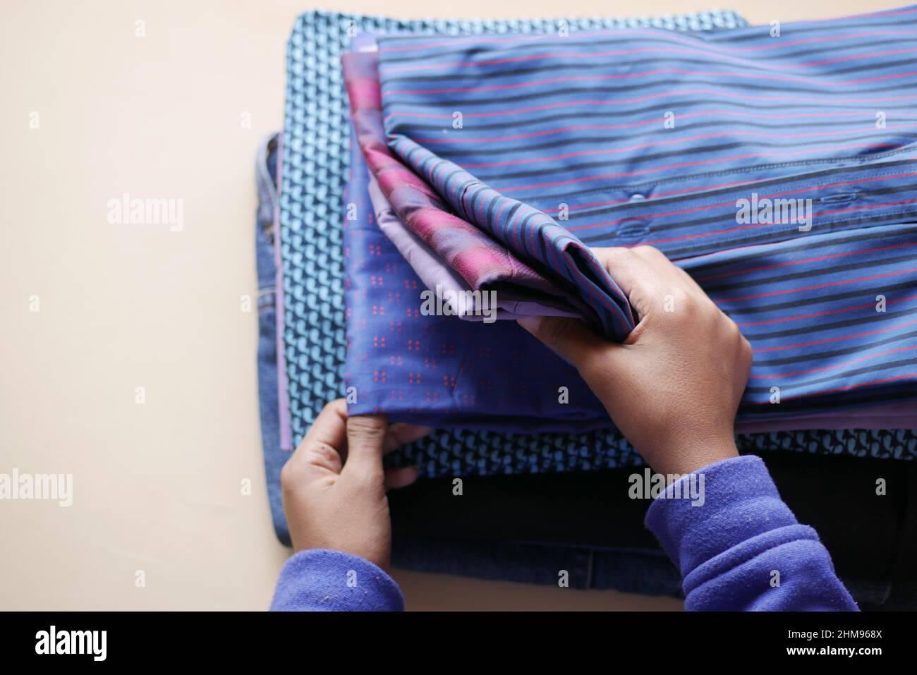 men's hand counting clothes on table Stock Photo - Alamy