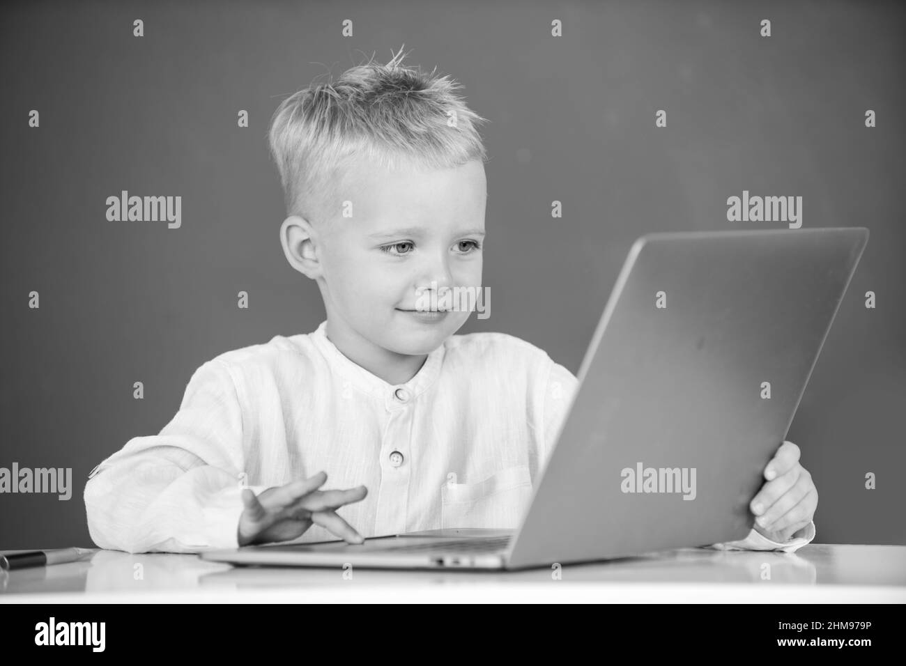 School boy learn lesson sitting at desk, studying online e-learning use ...