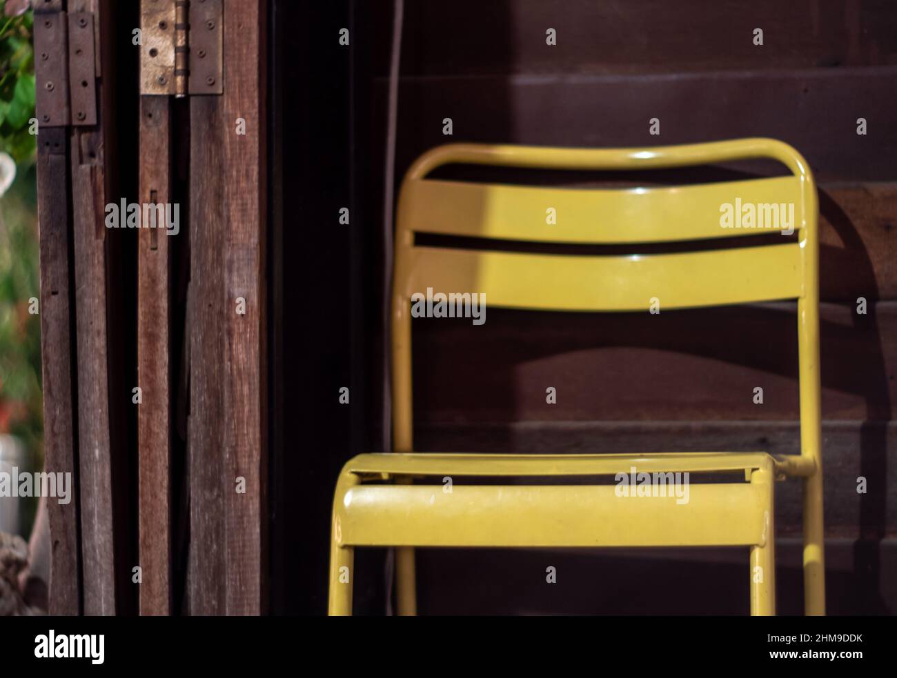 Yellow color steel chair with the old wooden room Stock Photo - Alamy