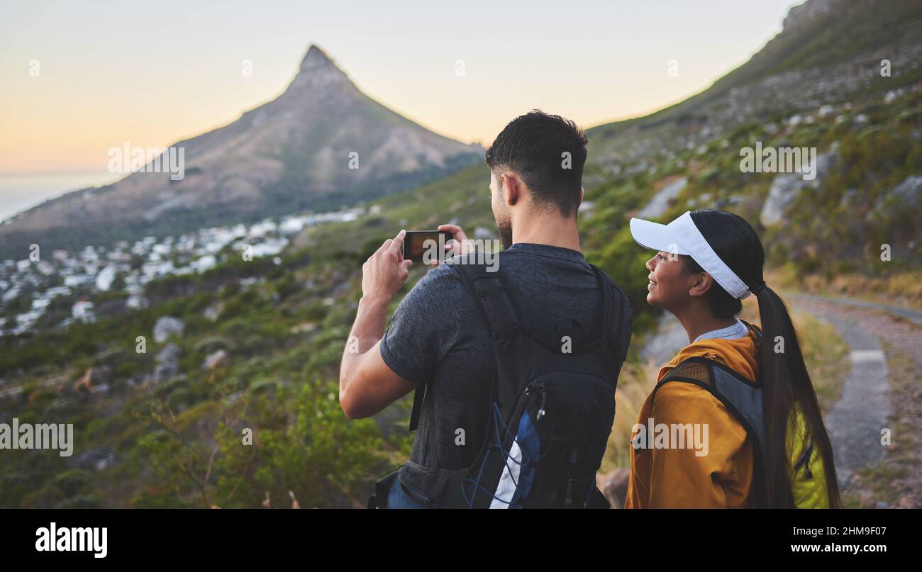This view is simply stunning. Shot of a young couple taking photos ...