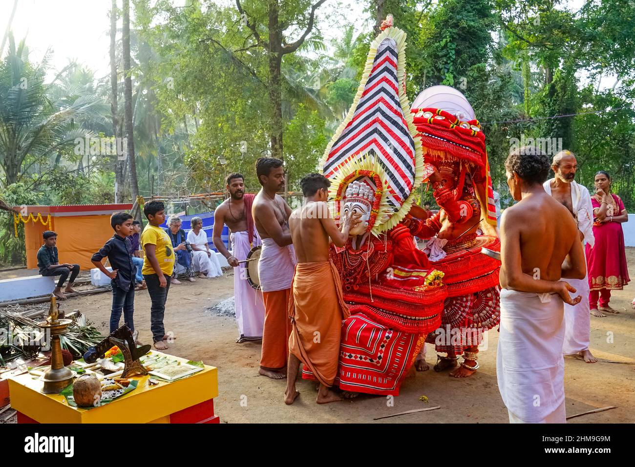A Theyyam performer is adorned with traditional colourful costume and ...
