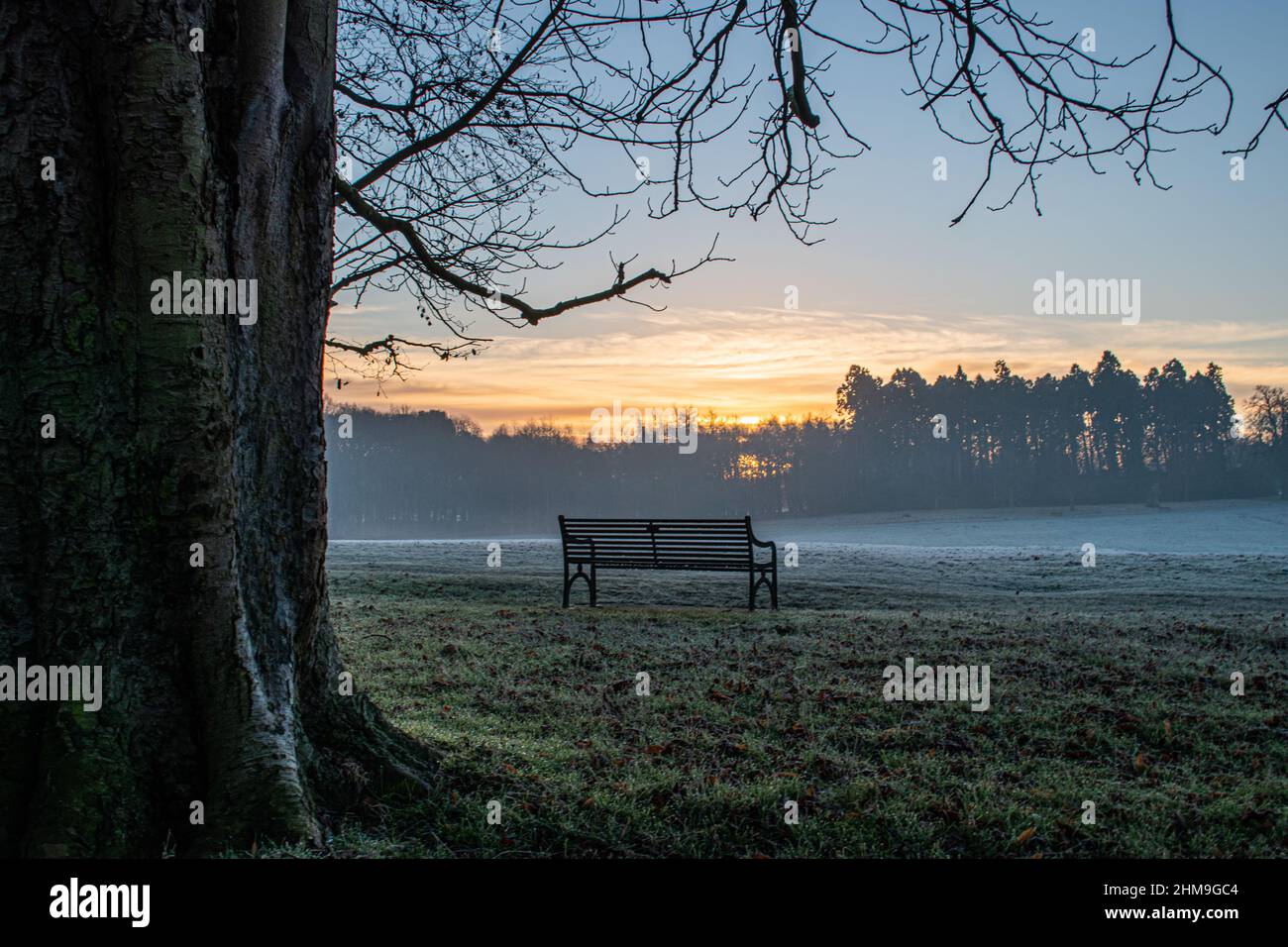 Lonely bench watching over a winter's sunrise over Wollaton Hall ...