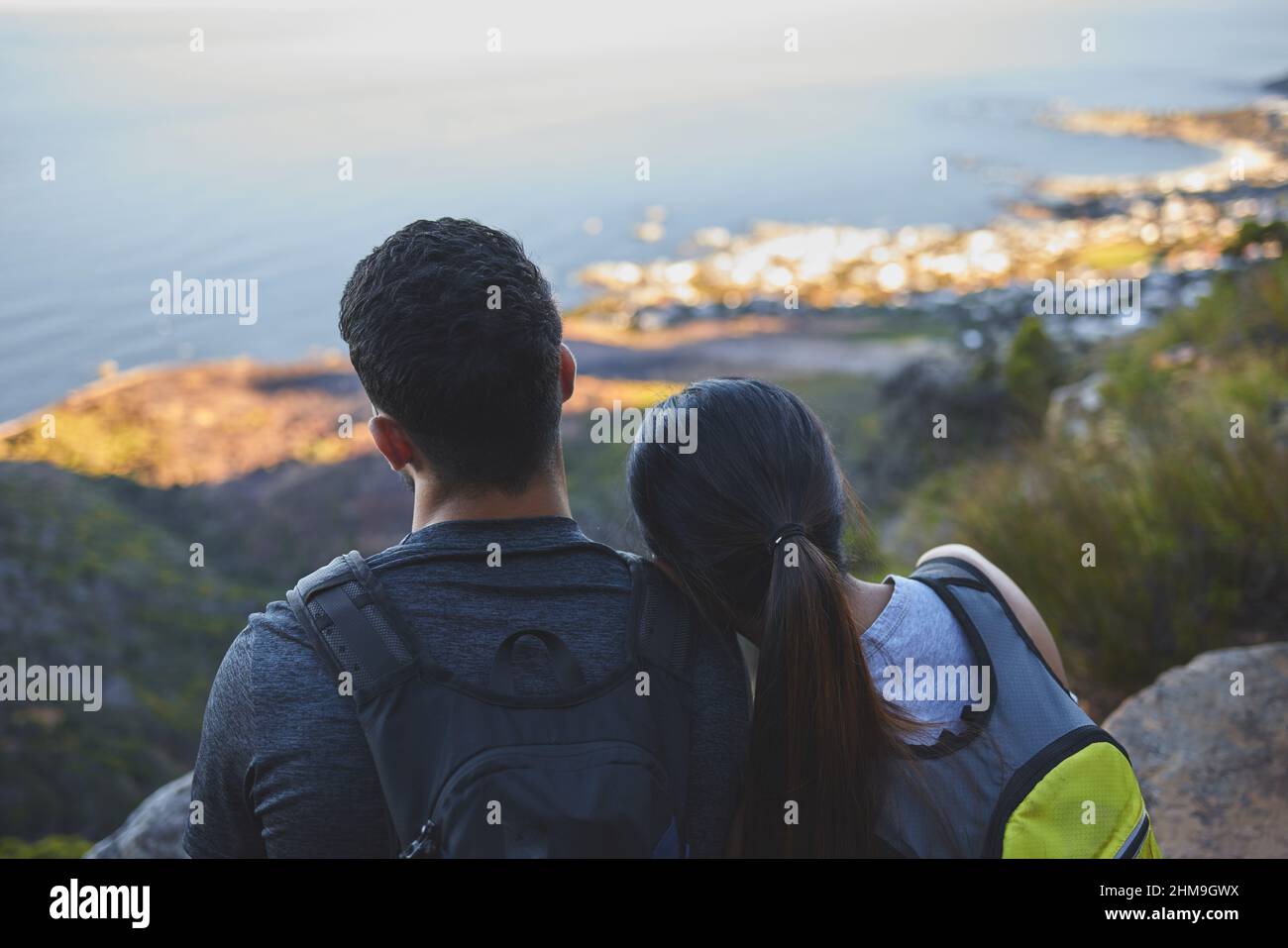 .. Shot of a young couple enjoying the sunset view while out on a hike ...