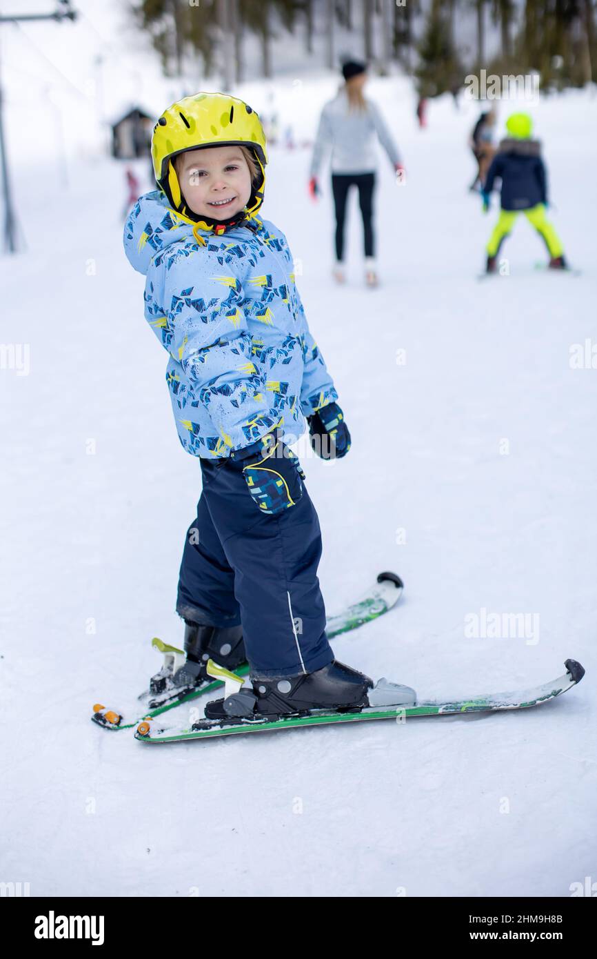 Little toddler boy, preschool child, skiing for the first time on small ...