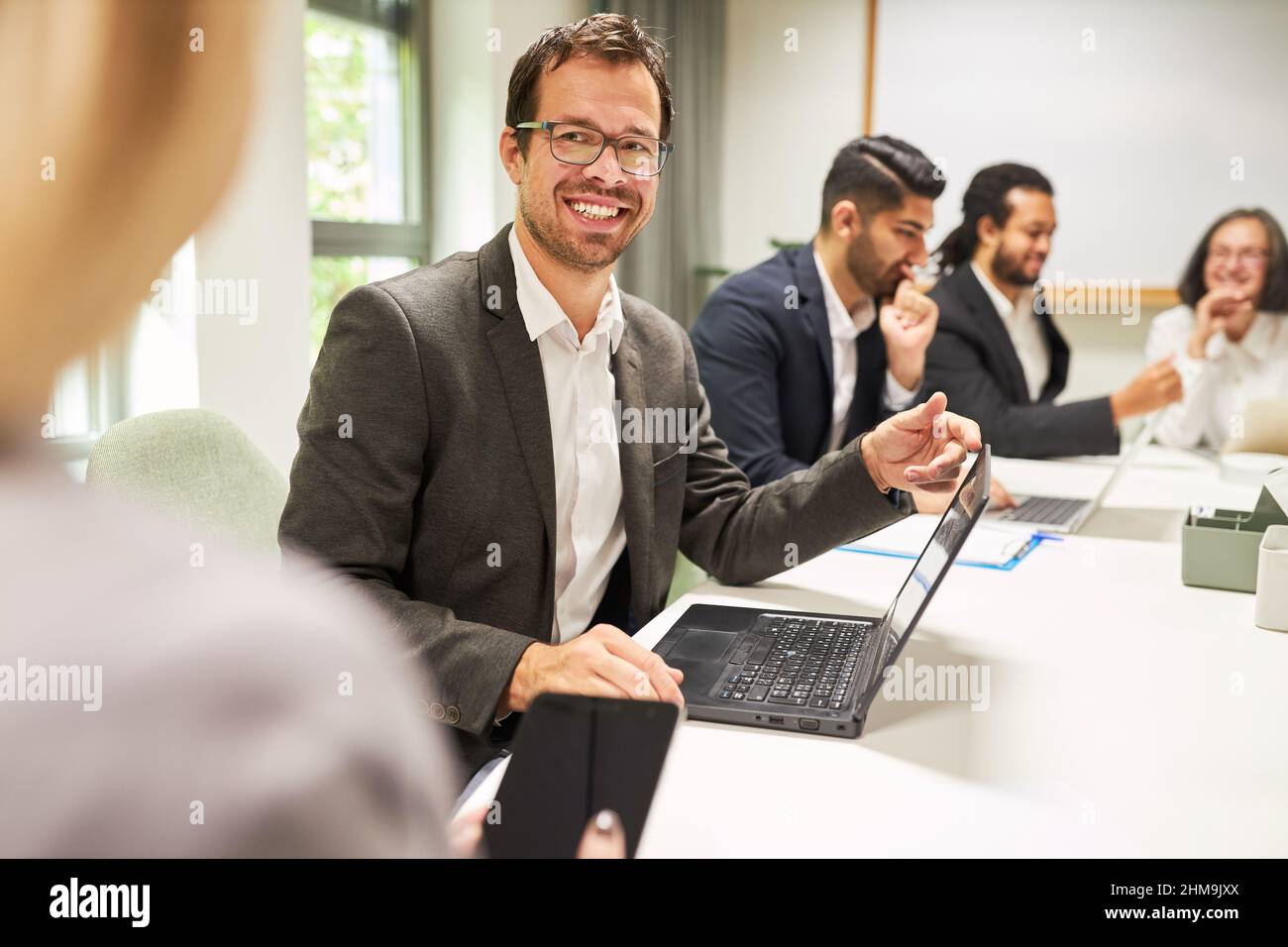 Happy business man as consultant with laptop computer at conference ...