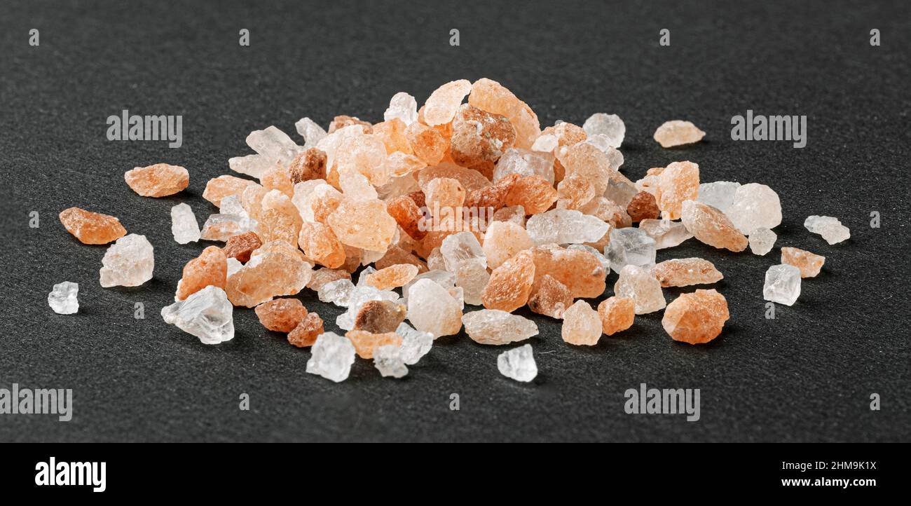 Pile of pink himalayan salt on black background Stock Photo - Alamy