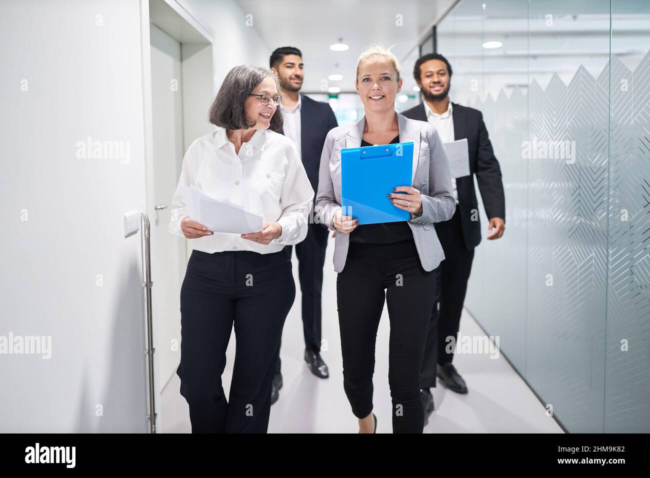 Group of business people with documents in the hallway of the office on ...