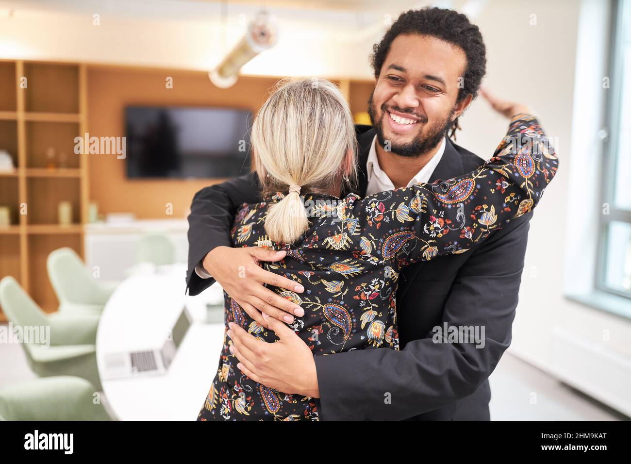 African businessman hugs female colleague to greet international ...