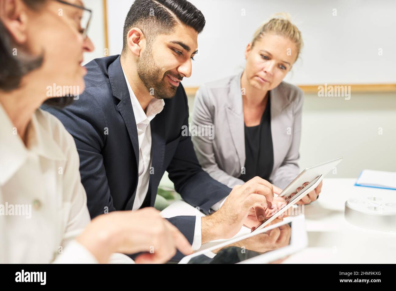 Three business people working together with tablet computer in the ...