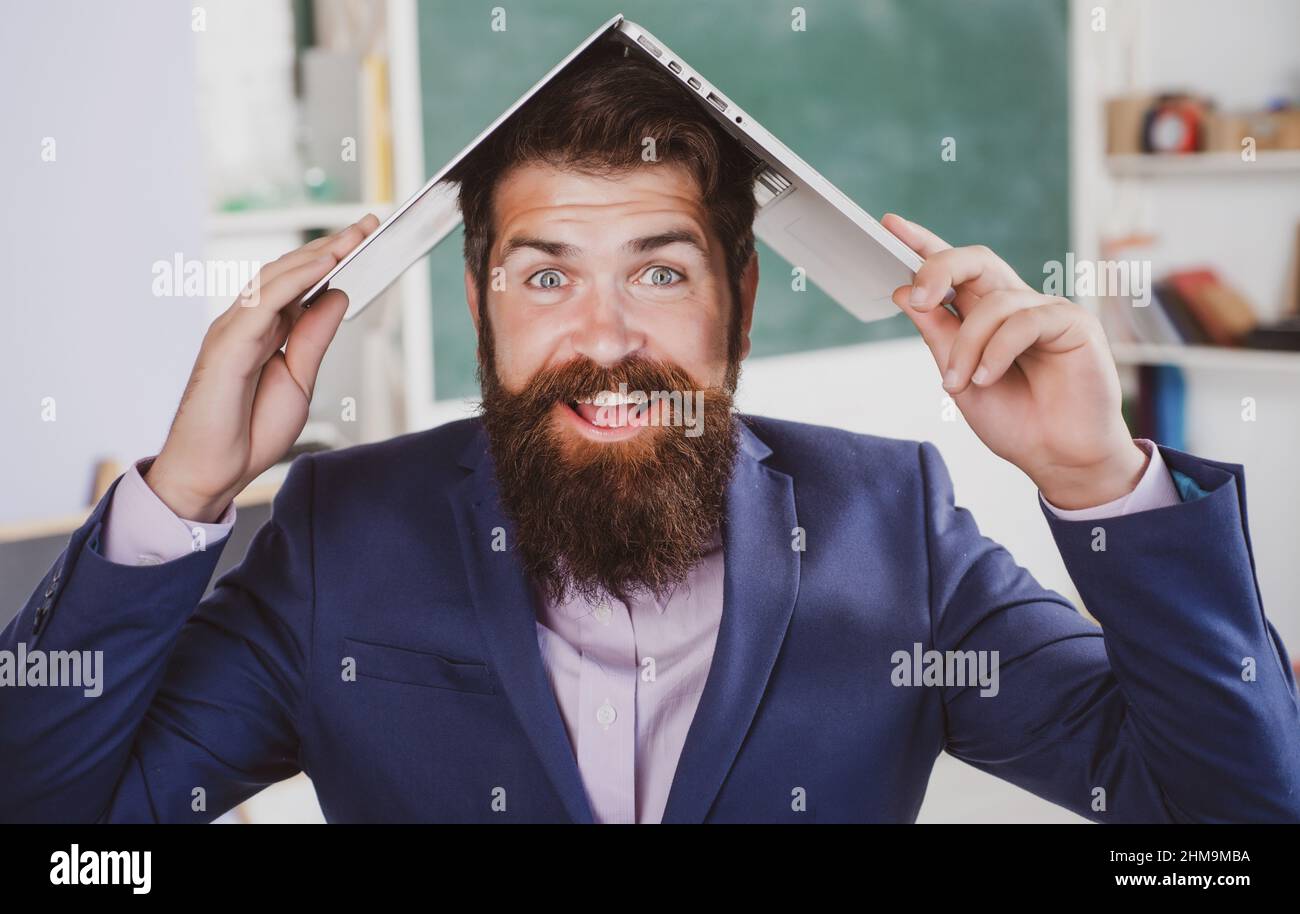 Funny teacher with laptop notebook in classroom at school. Excited ...