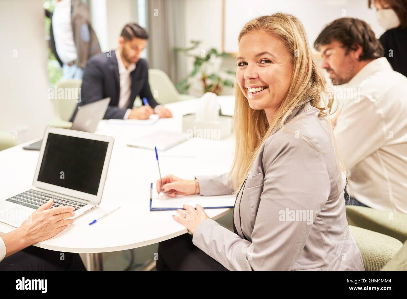 Happy young business woman as a trainee in training in the office or in ...