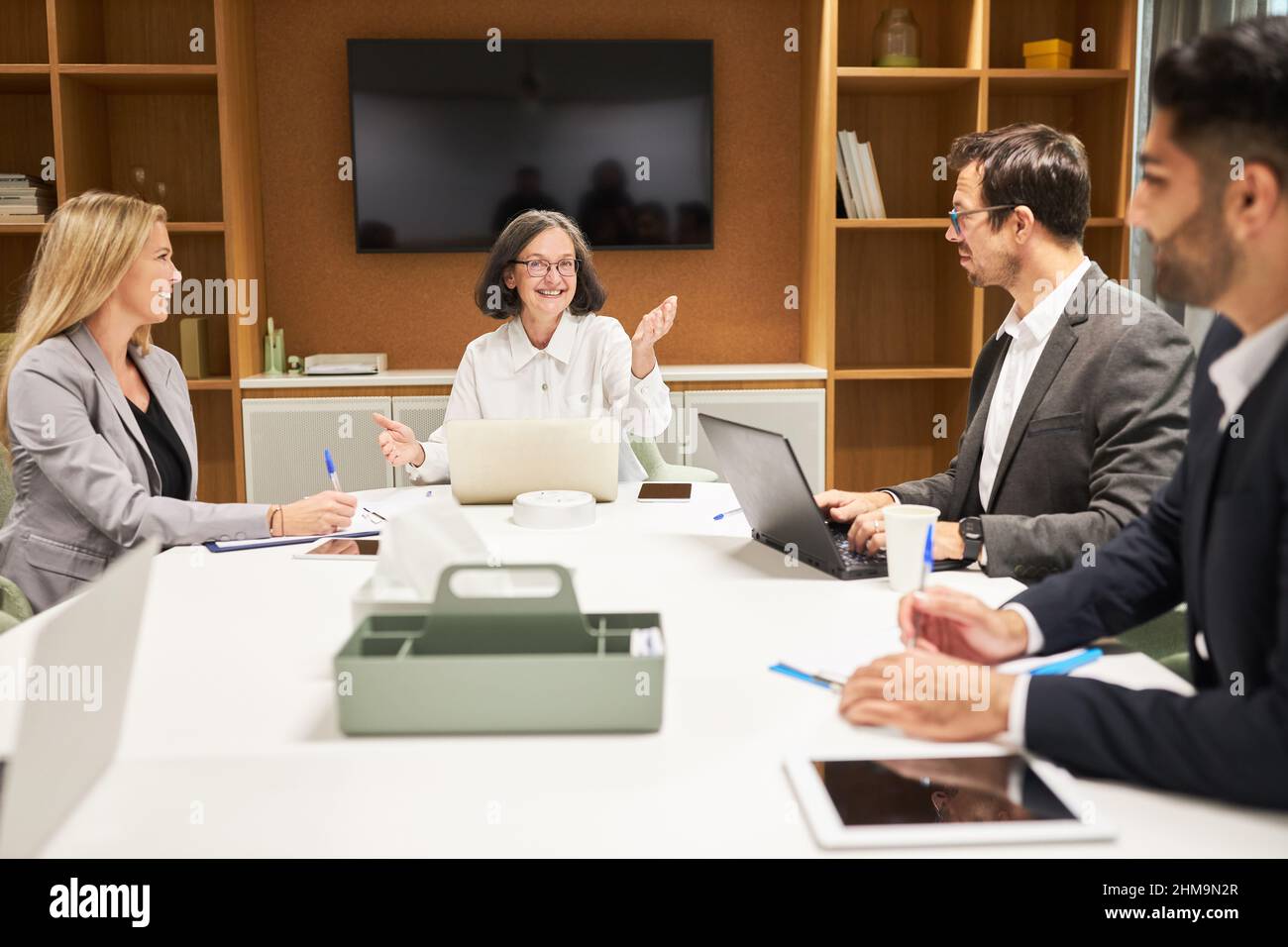 Senior business woman as boss discusses project planning with her team ...