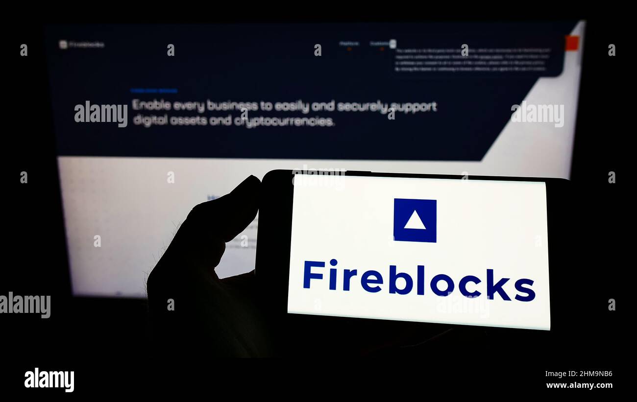 Person holding cellphone with logo of US crypto software company ...