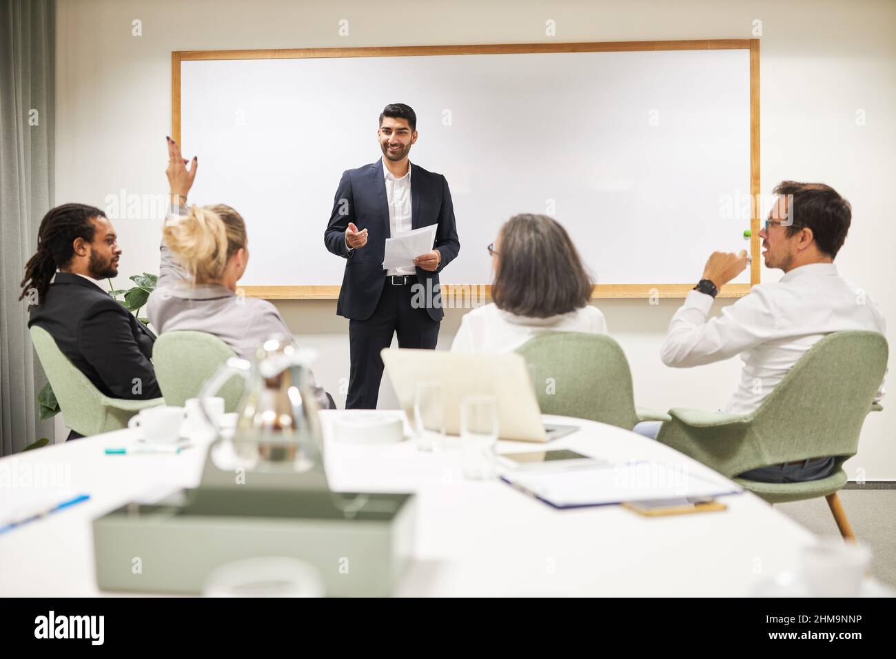 Business people and speaker after a presentation having a discussion in ...