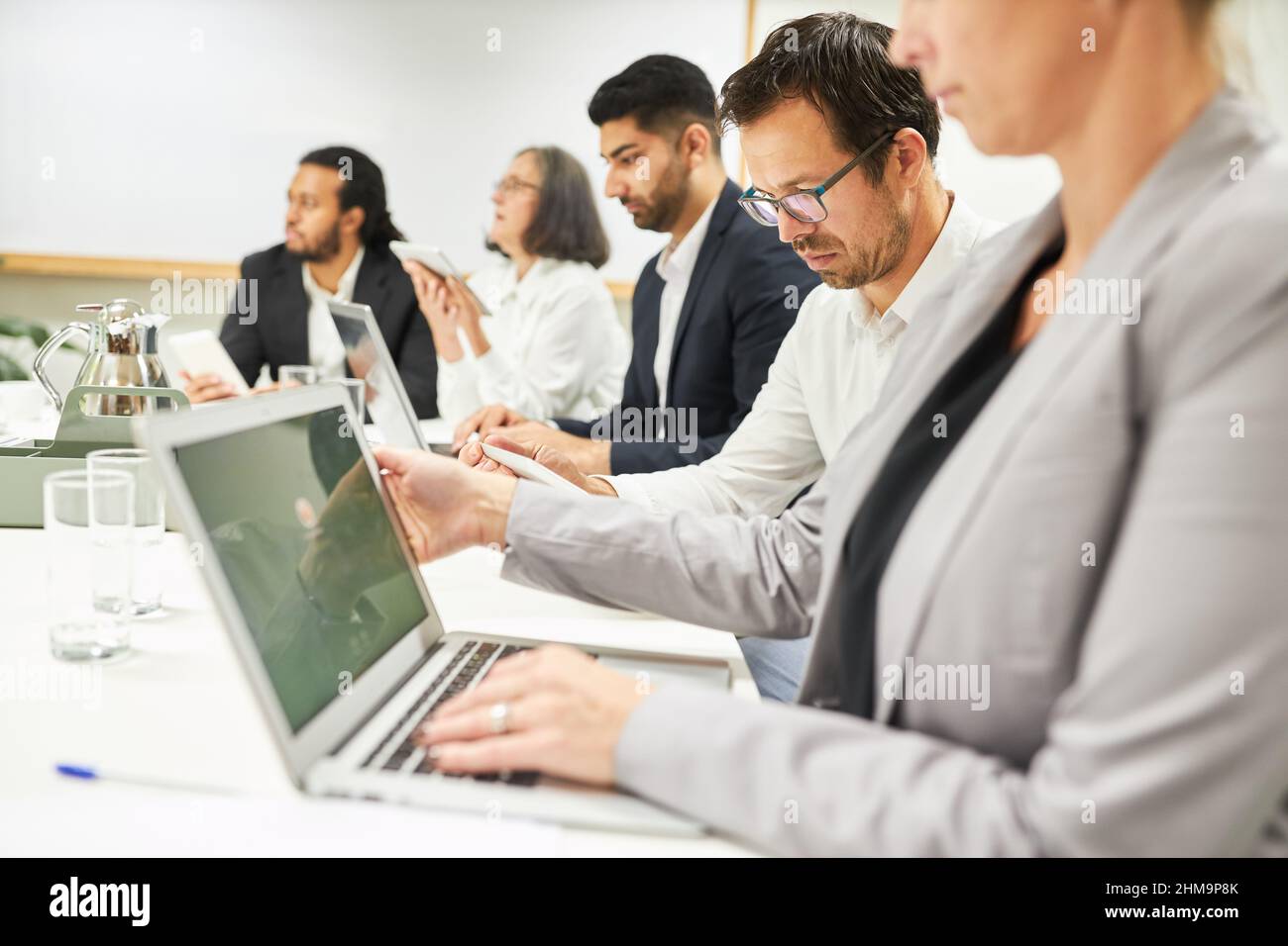 Group of business people working together with laptop computers in a ...
