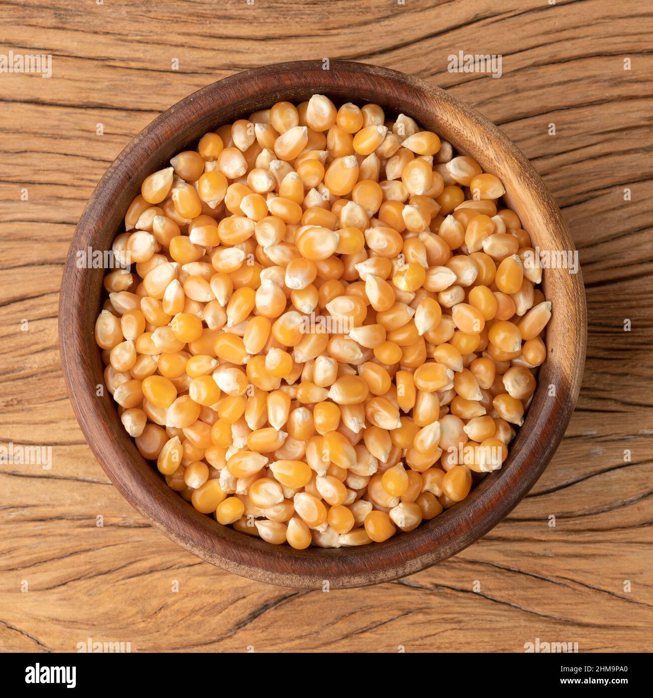 Dried corn or popcorn grains in a bowl over wooden table Stock Photo ...