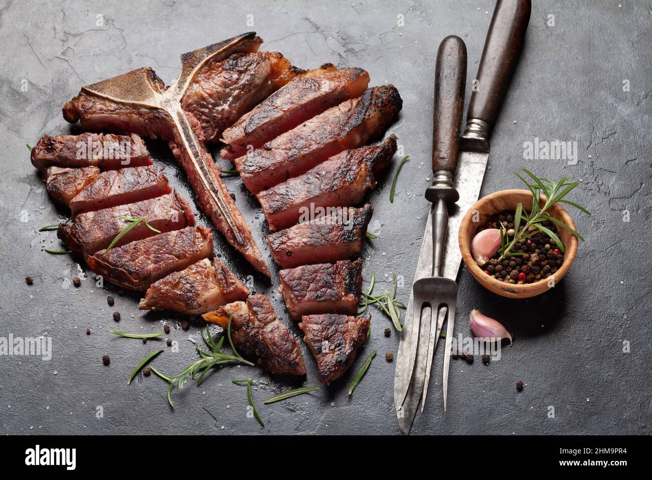 Grilled porterhouse beef steak. Sliced T-bone with herbs and spices ...