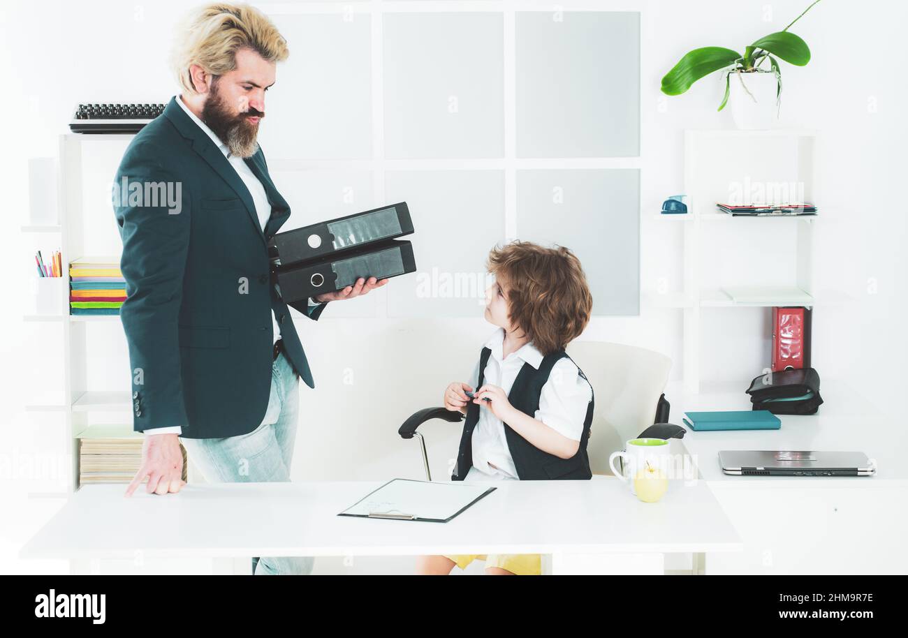 Little kid playing to be boss on a business desk in office. Business ...