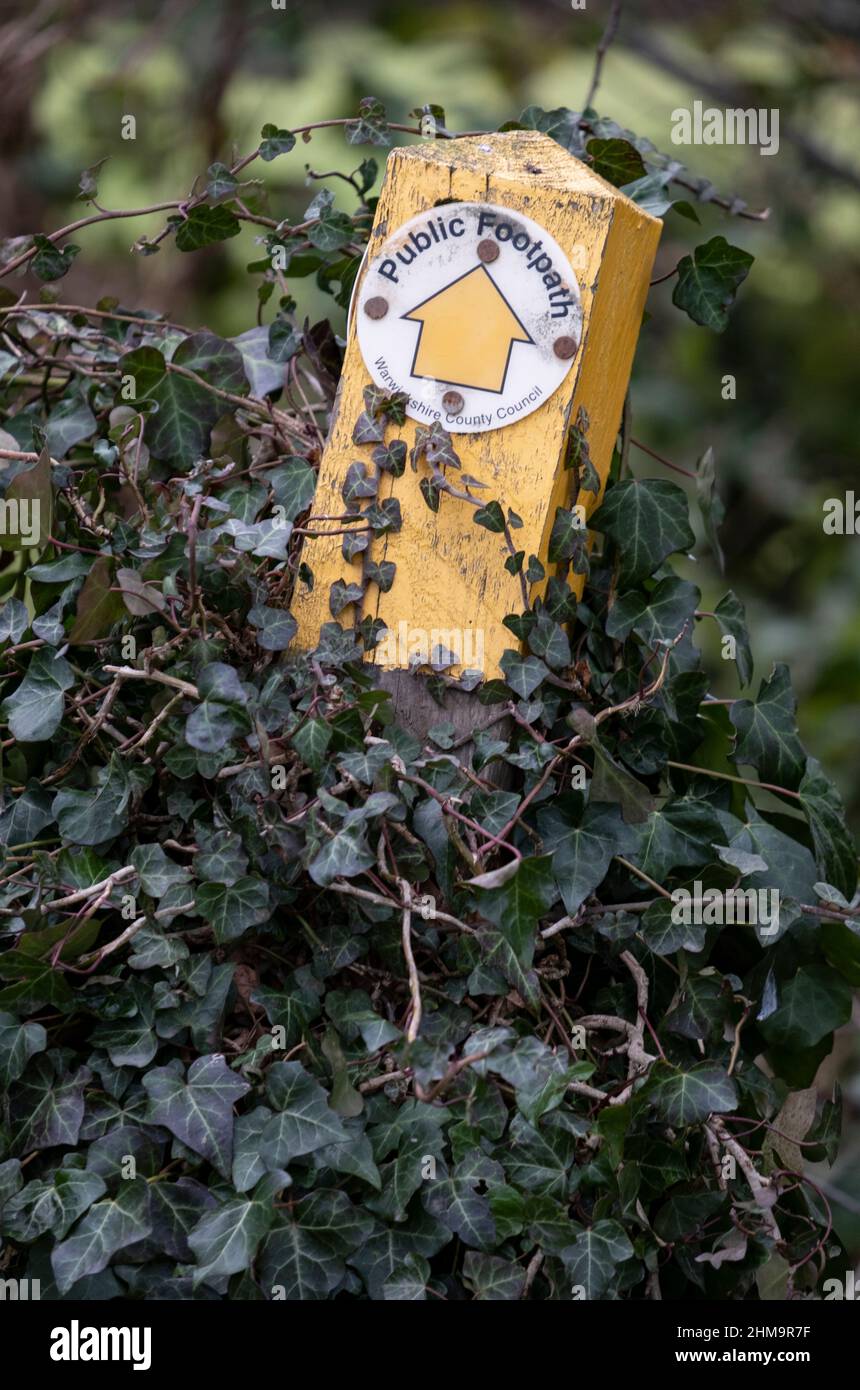 A public footpath right of way sign which is almost hidden in the ...