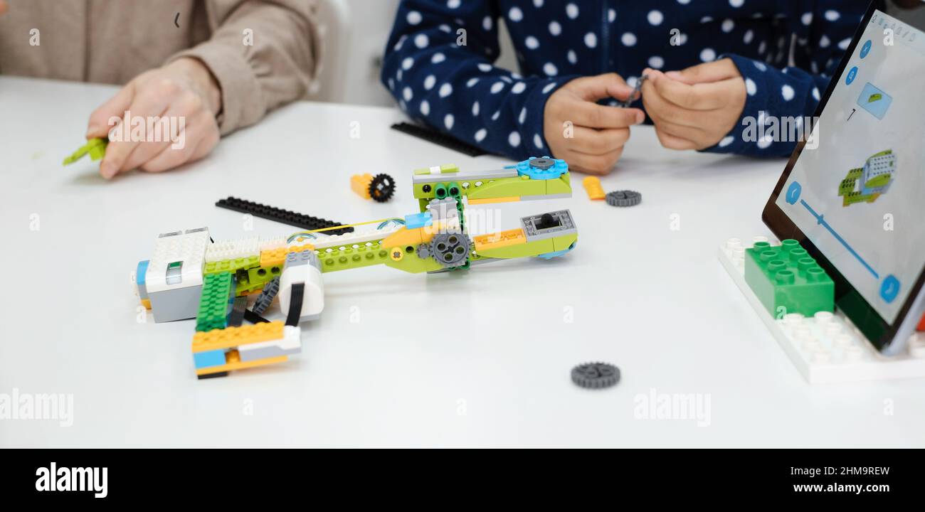 Coding Class, school girl constructing robot arm mechanism. multiethnic ...