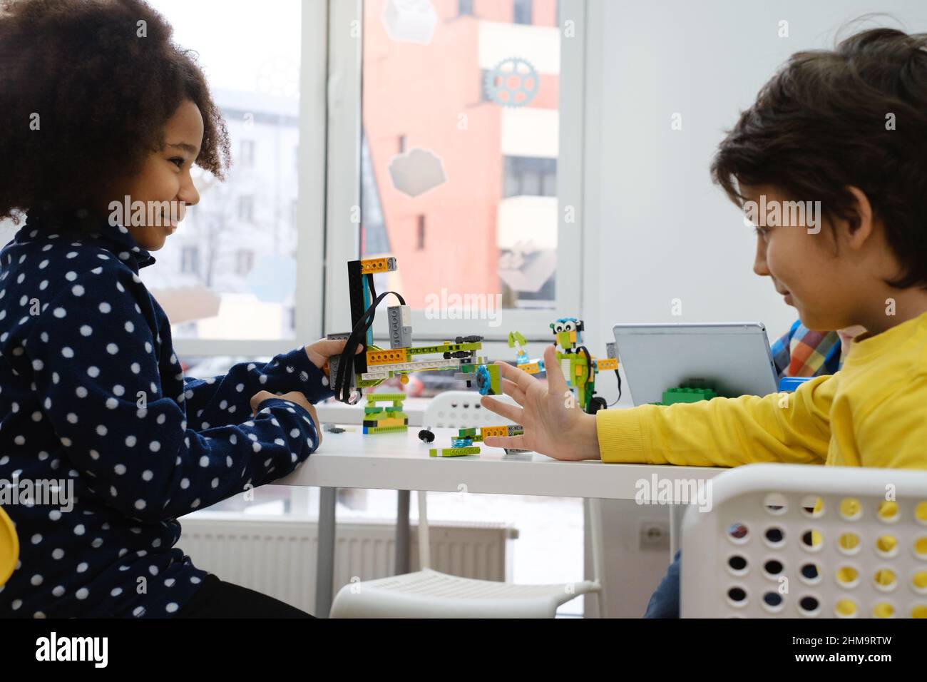 Coding Class, school girl constructing robot arm mechanism. multiethnic ...