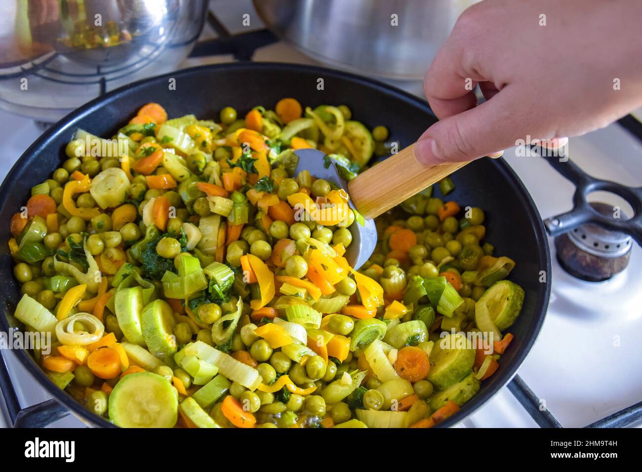 Process of cooking saute at home. Woman's hand mixed stewed vegetables ...