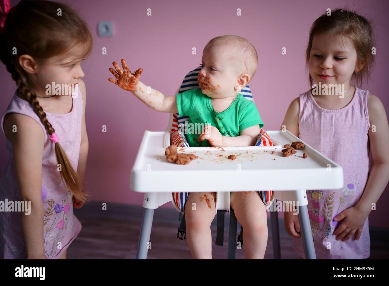 sisters feed brother, he is all in chocolate Stock Photo - Alamy