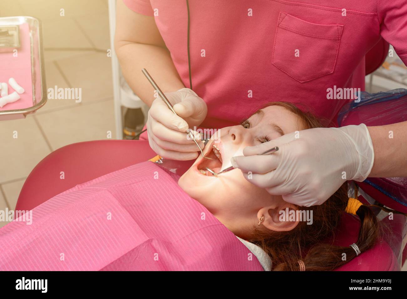 Treatment of baby teeth in a child, a little girl at the dentist ...