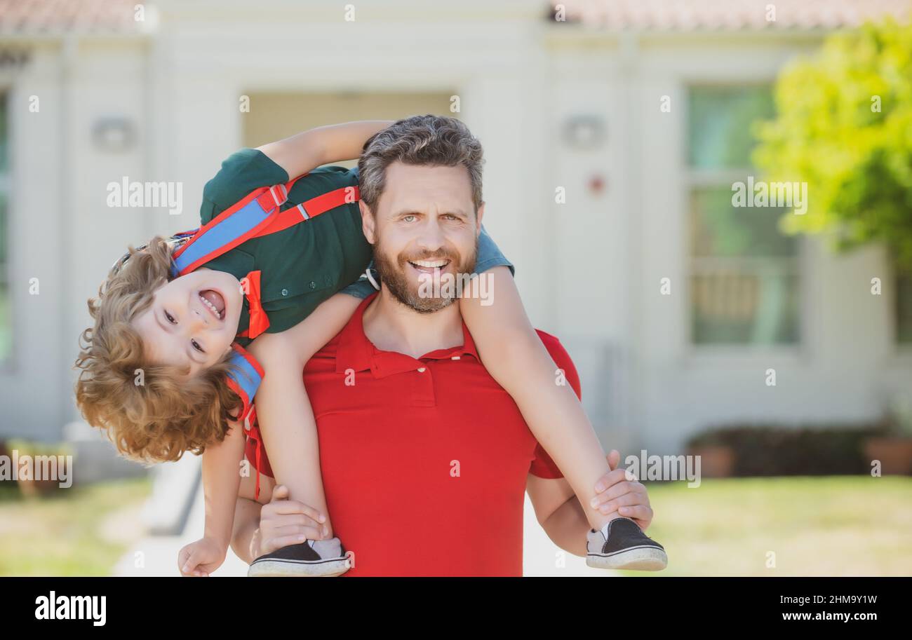 Father giving son piggyback ride after come back from school. School ...
