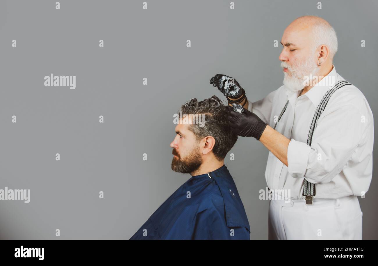 Professional hairdresser coloring man hair. Process of a guy color hair ...