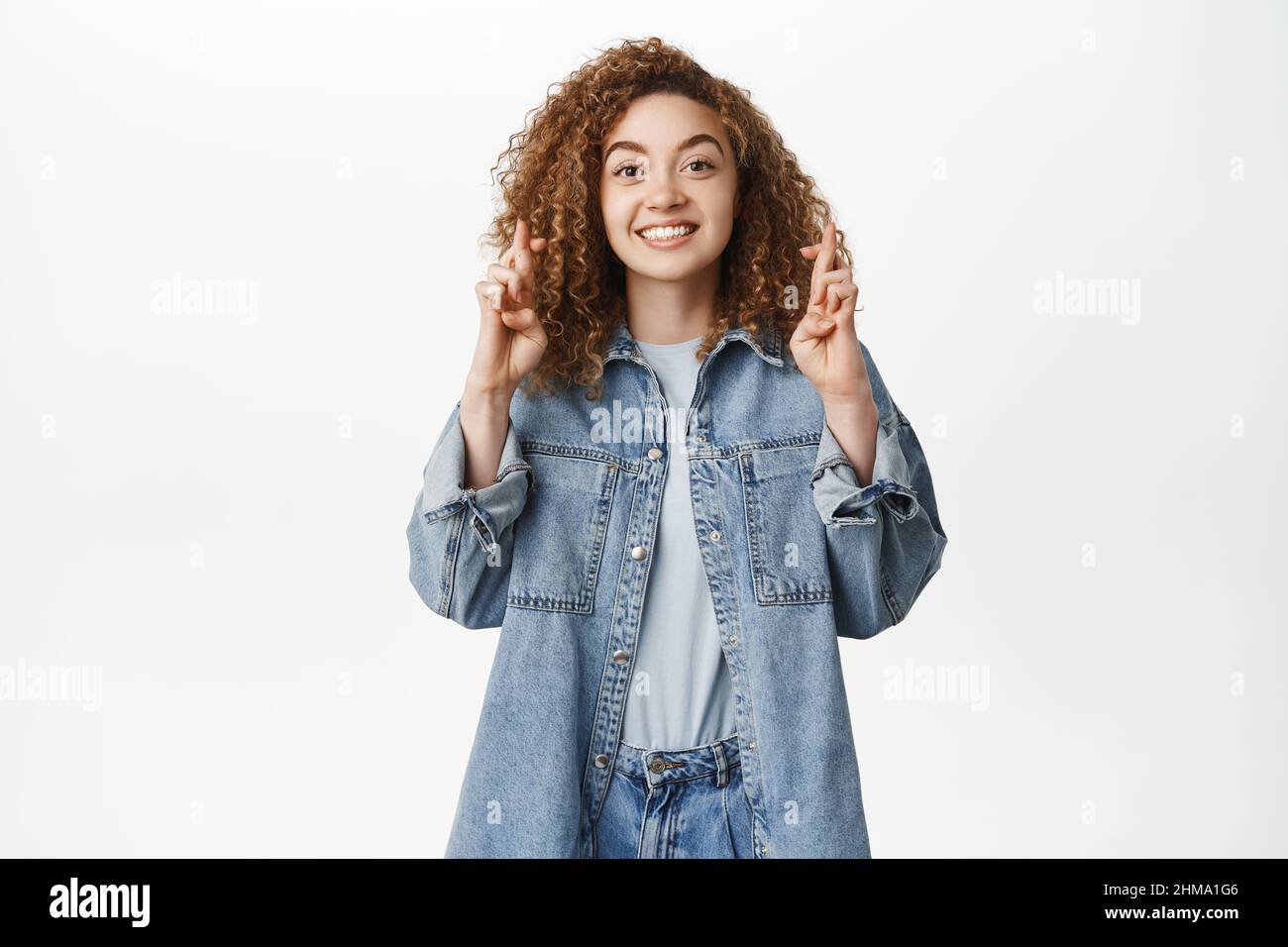Hopeful girl makes wish. Young woman cross fingers for good luck ...