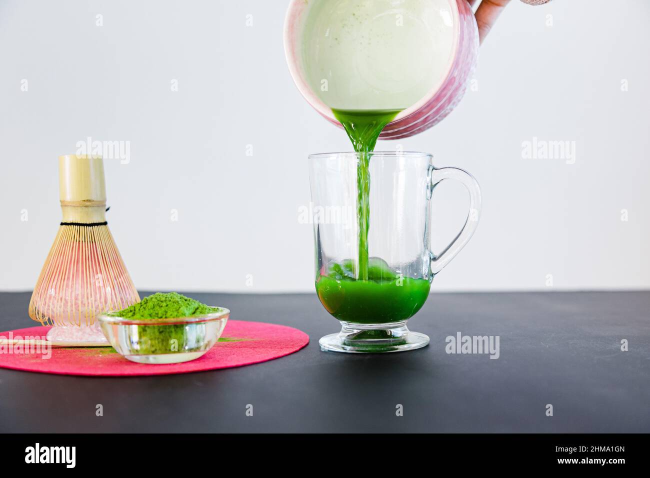 Crop anonymous person pouring traditional oriental matcha from bowl ...