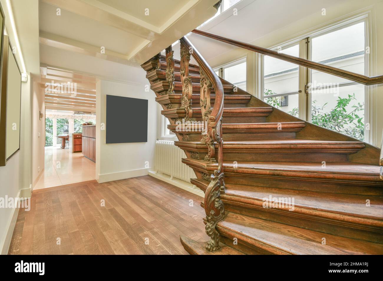 Stairway with ornamental railings placed near window and radiators in ...