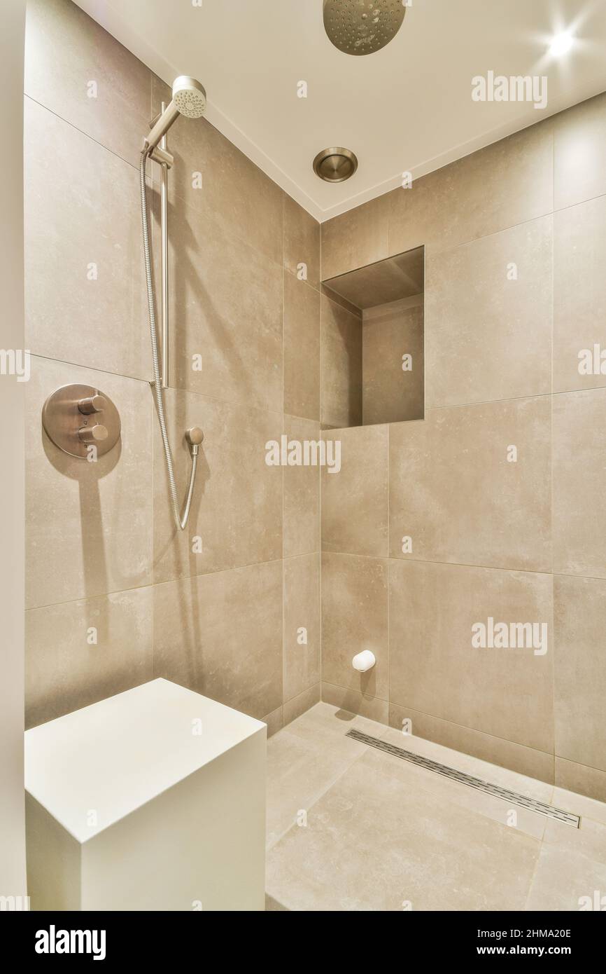 Interior of modern shower cabin with tiled walls and built in shelf and ...