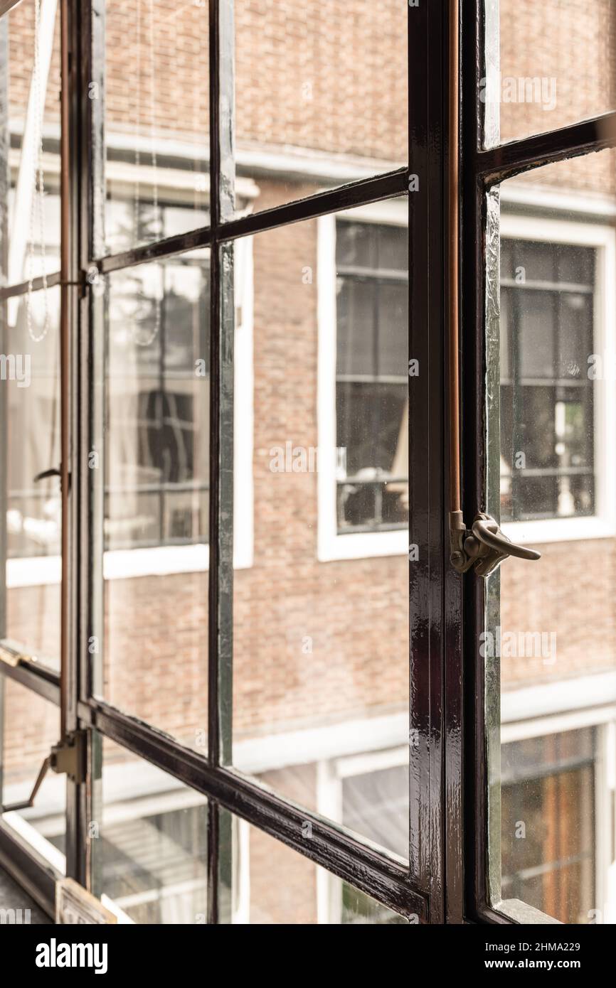 Big glass window with black frame and metal locks in light room ...