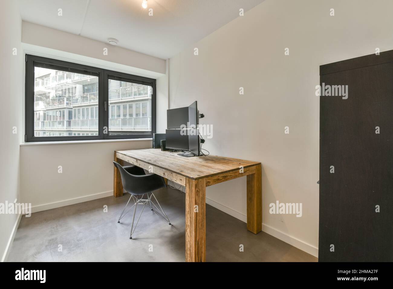 Contemporary monitors with black screens on stand placed on wooden ...