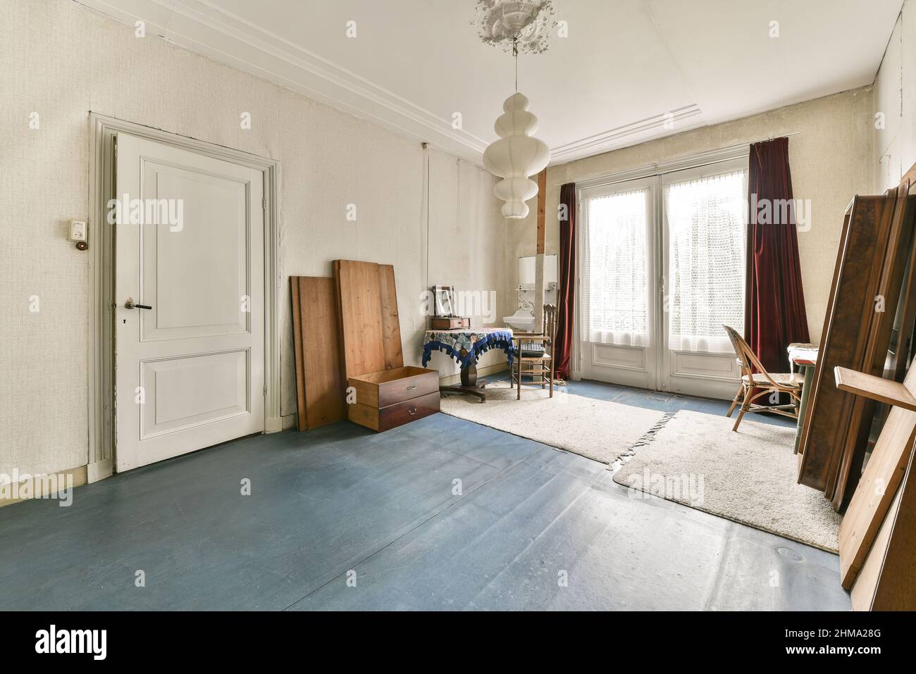 Interior of spacious room with various old junk placed on shabby floor ...