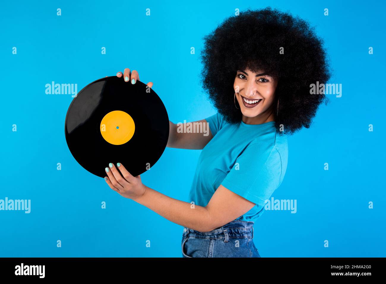 Side view of smiling optimistic Hispanic female meloman with retro ...