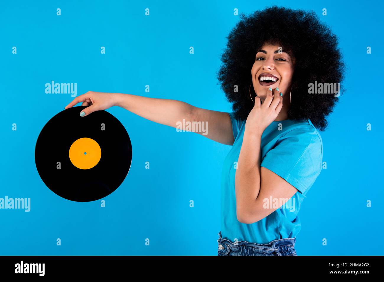 Side view of smiling optimistic Hispanic female meloman with retro ...