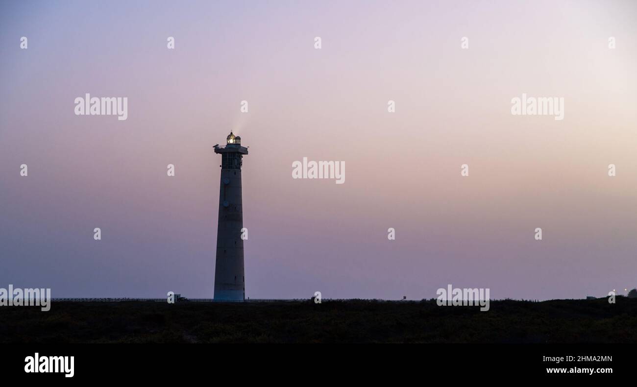 Scenic view of tower of beacon glowing on background of sunset sky at ...