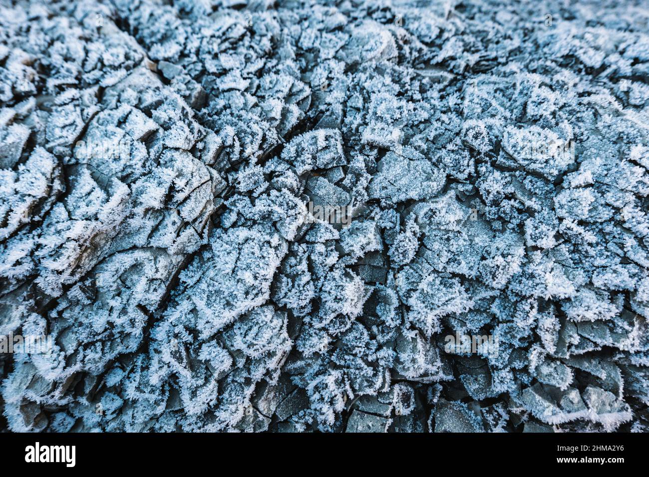 Full frame abstract backdrop of cracked rocky texture with frost on ...