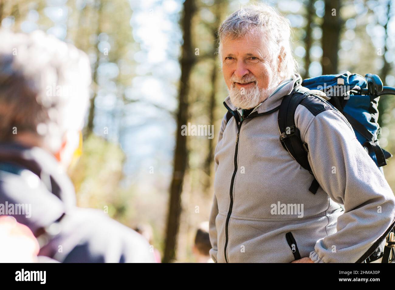 Senior hikers with backpacks enjoying trekking in autumn woods while ...