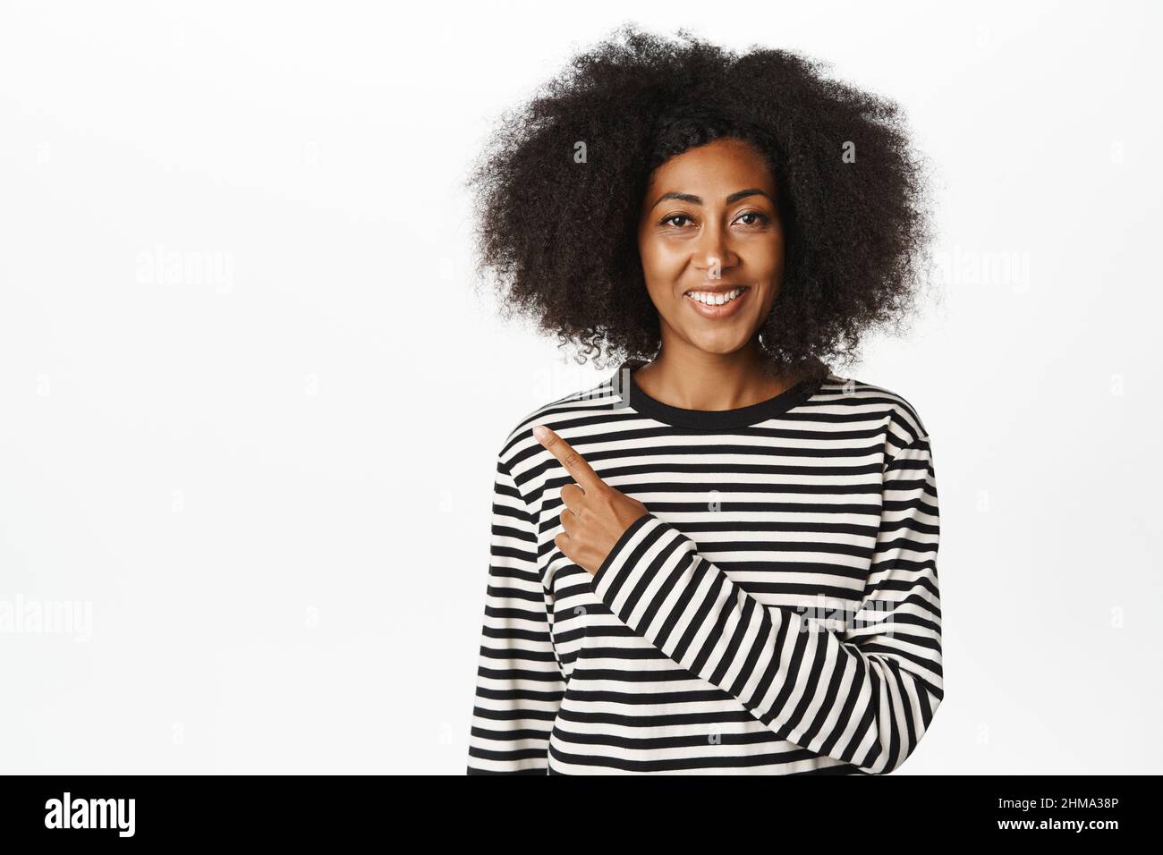 Close up of enthusiastic african american woman pointing finger left ...