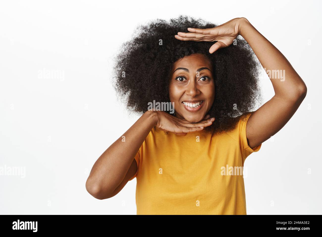 Close up of smiling african american woman showing head frame gesture ...