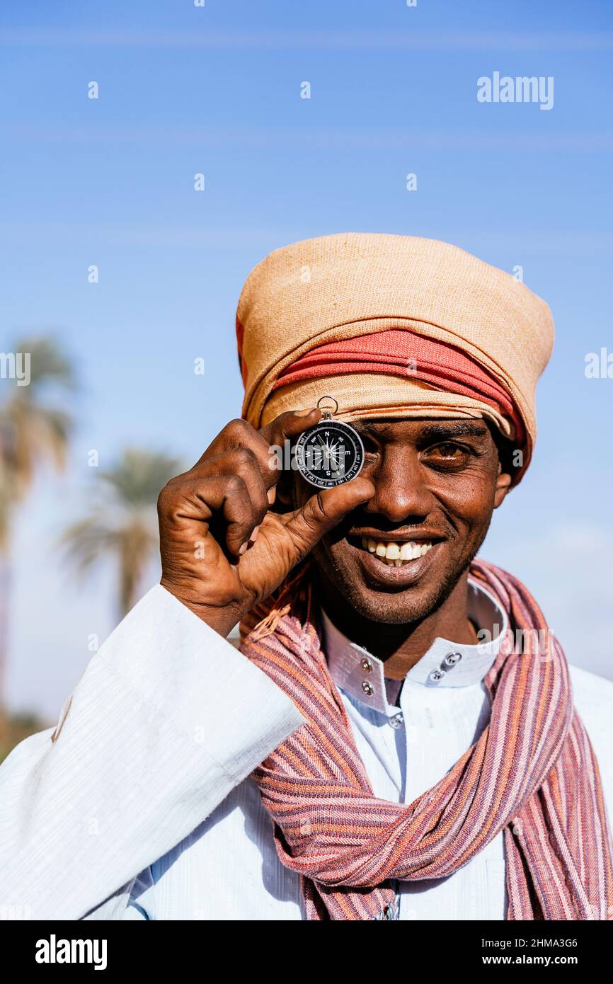 Positive Egyptian male traveler wearing traditional turban covering eye ...