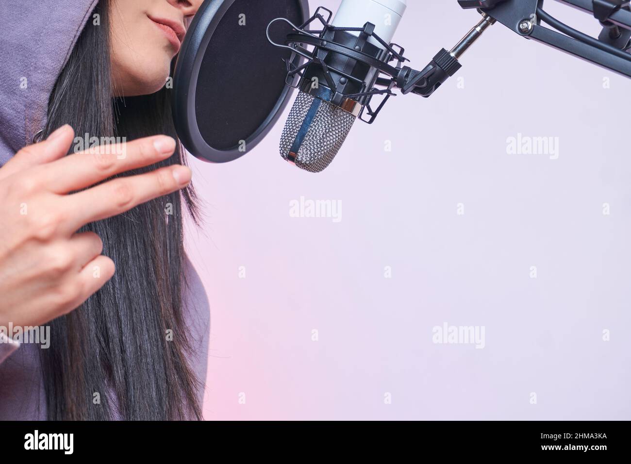 Cropped unrecognizable young talented female with hoodie and headphones ...
