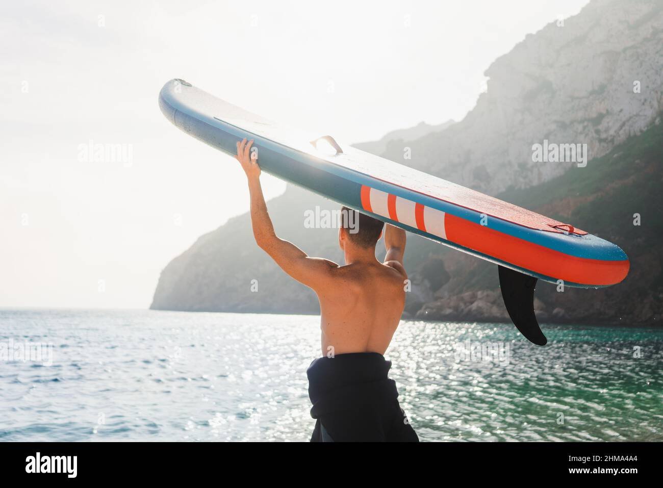 Back view of unrecognizable male surfer with SUP board for paddle ...