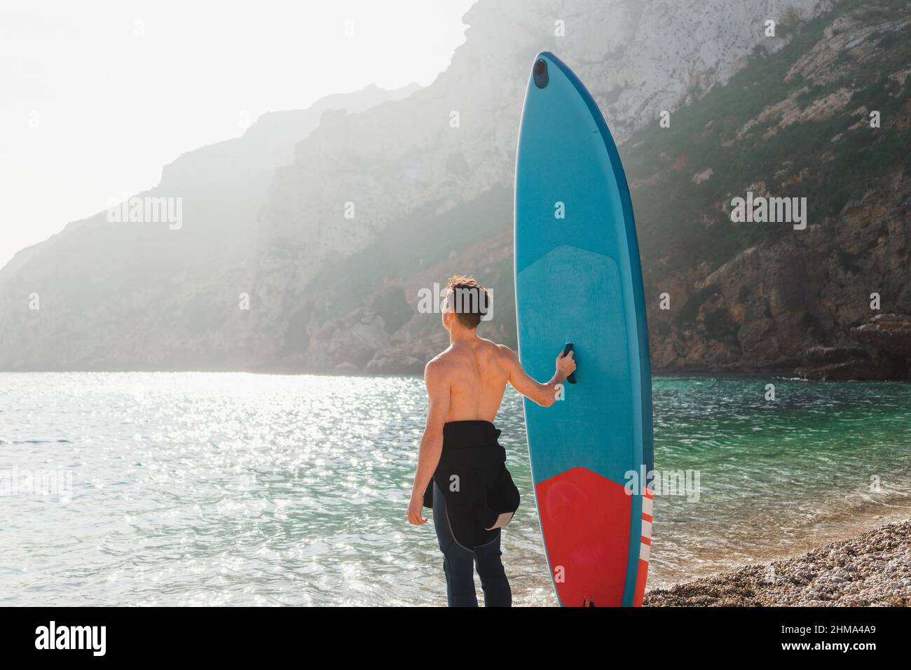 Back view of unrecognizable male surfer with SUP board for paddle ...