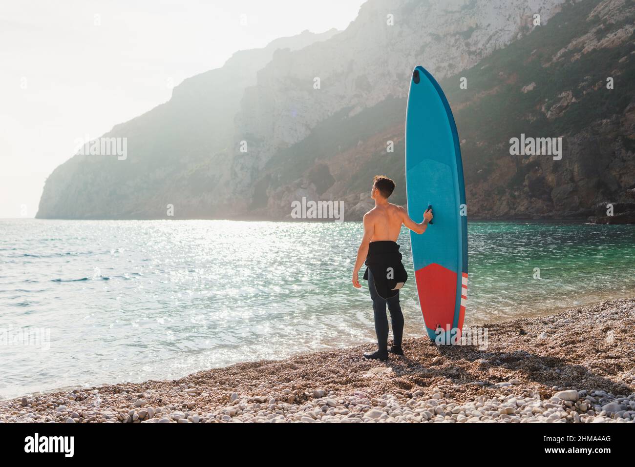Back view of unrecognizable male surfer with SUP board for paddle ...
