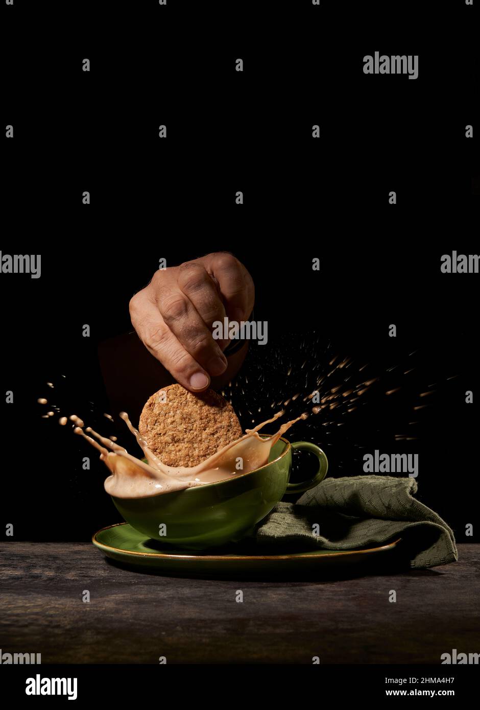 Crop anonymous person throwing tasty sweet cookies into green ceramic ...